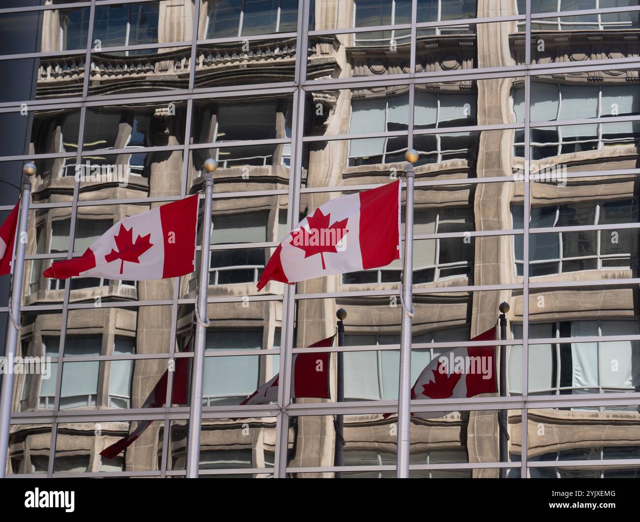 horizonal image of Canadian flag reflecting in the windows of a building in downtown Ottawa ...