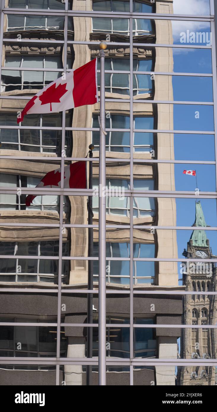 vertical image of Canadian flag reflecting in the windows of a building in downtown Ottawa ...