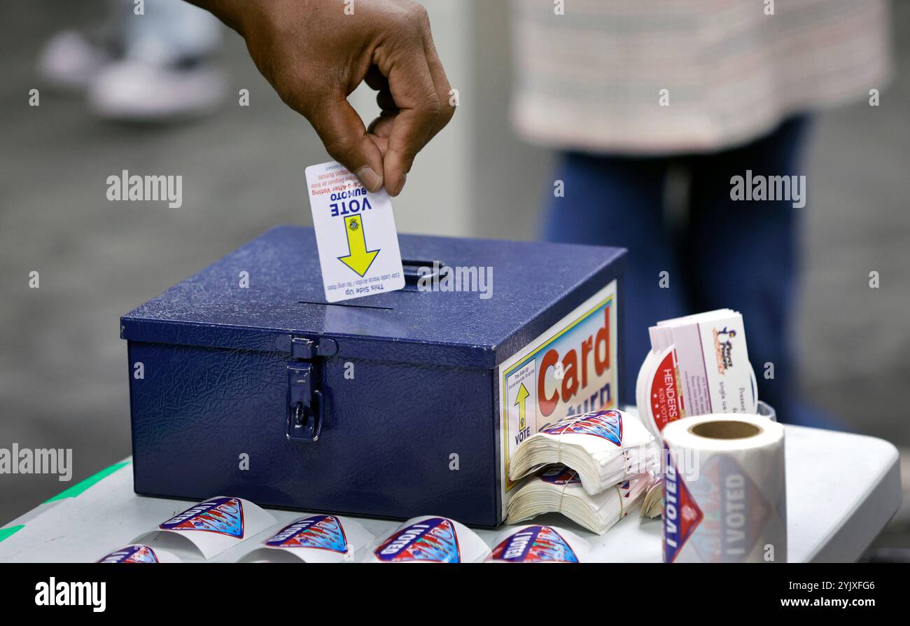FILE - A voter deposits his voting machine activation card into a box ...
