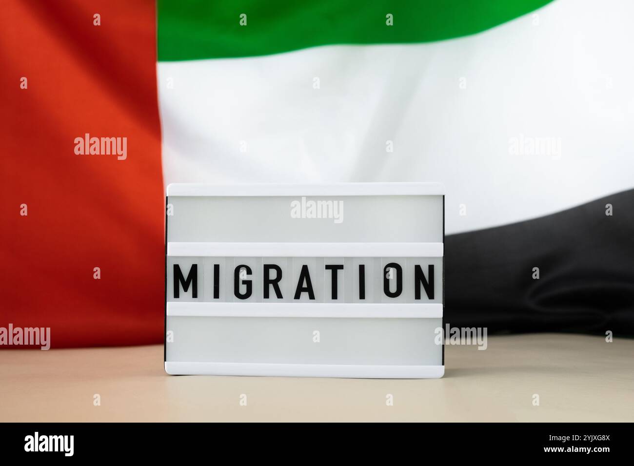 Lightbox with text MIGRATION on background of waving UAE flag made from ...