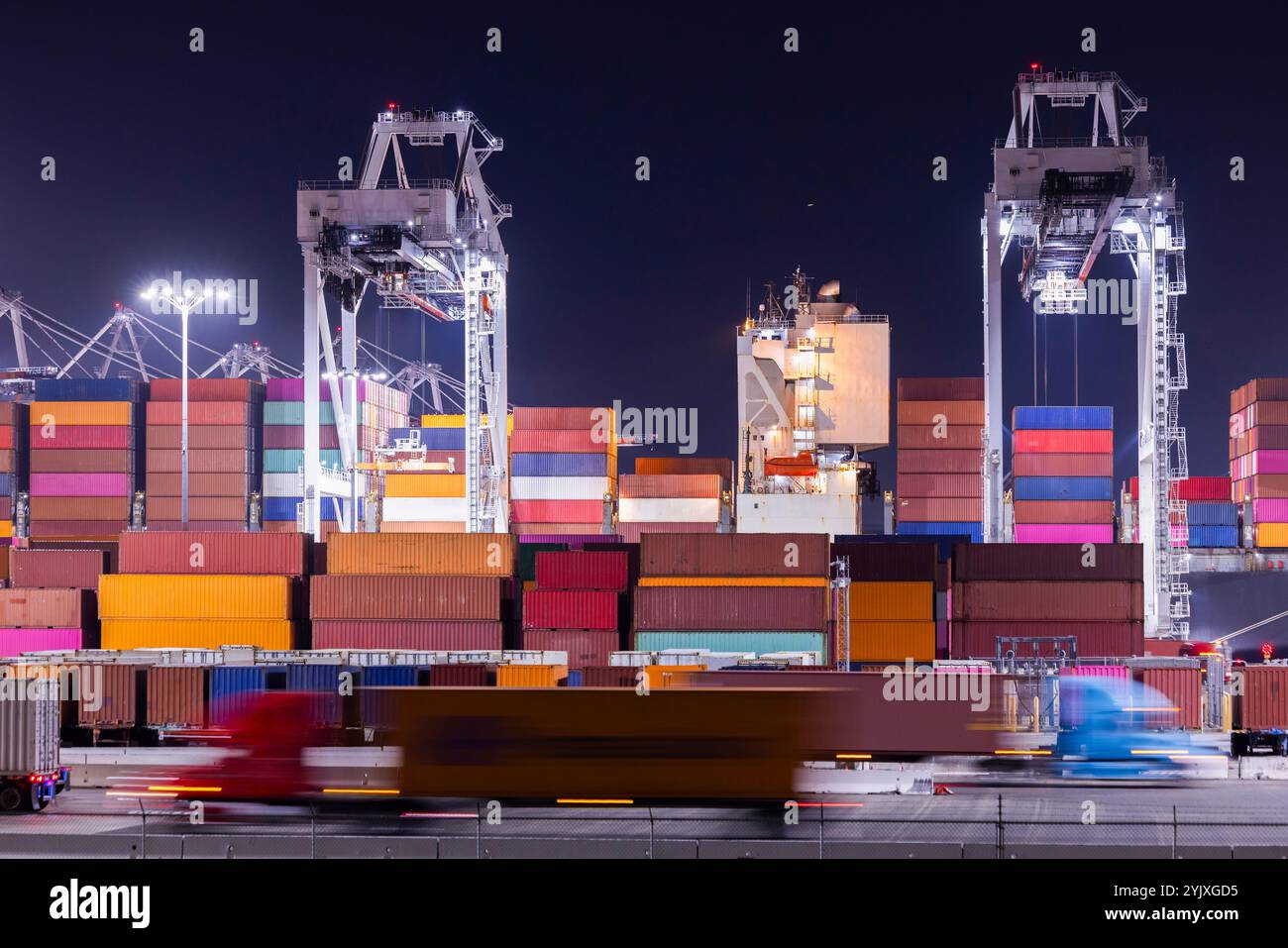 Cranes unload intermodal containers from a ship at port, with motion ...