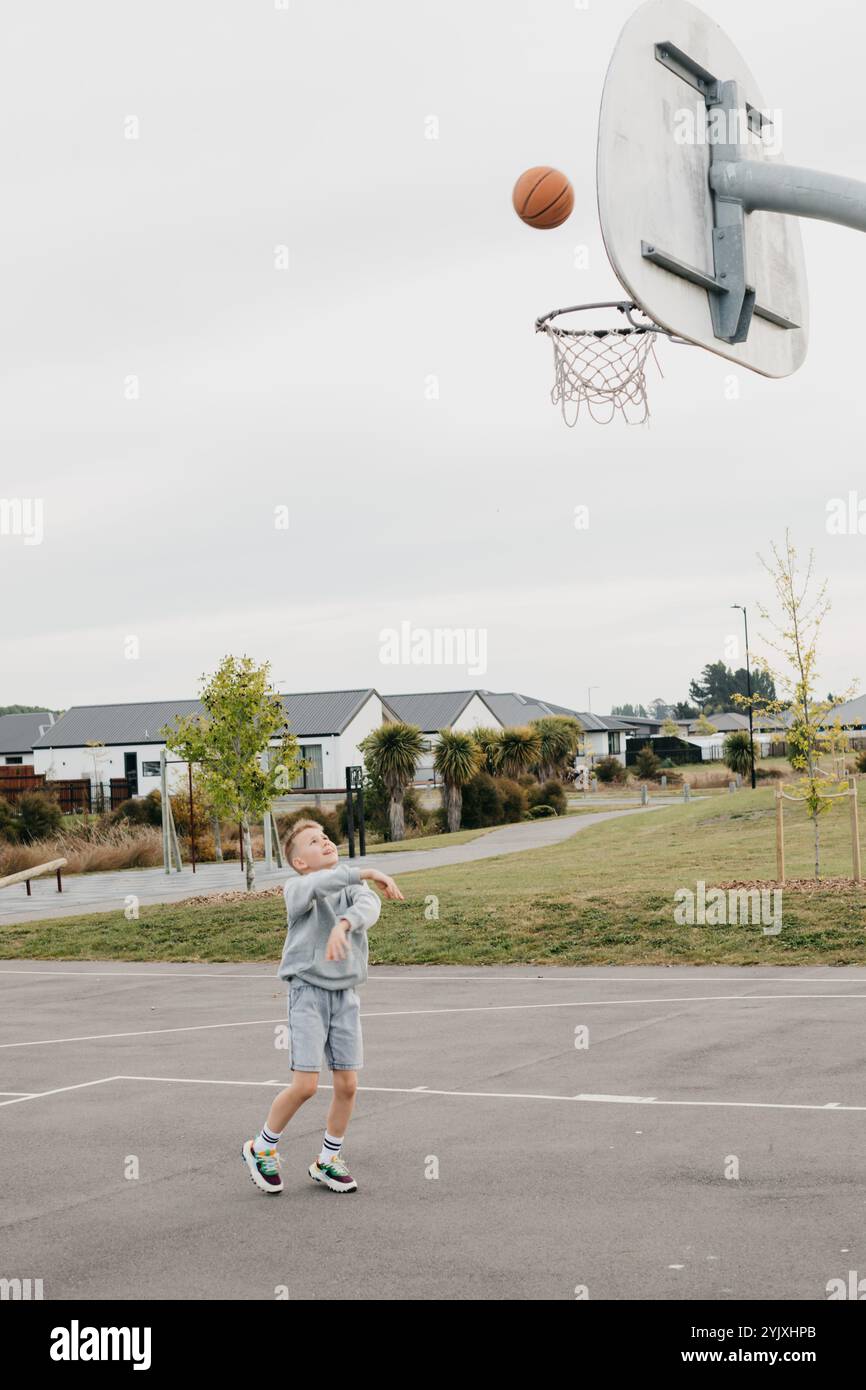 Teenage boy hits goal playing basketball on village sports ground Stock ...