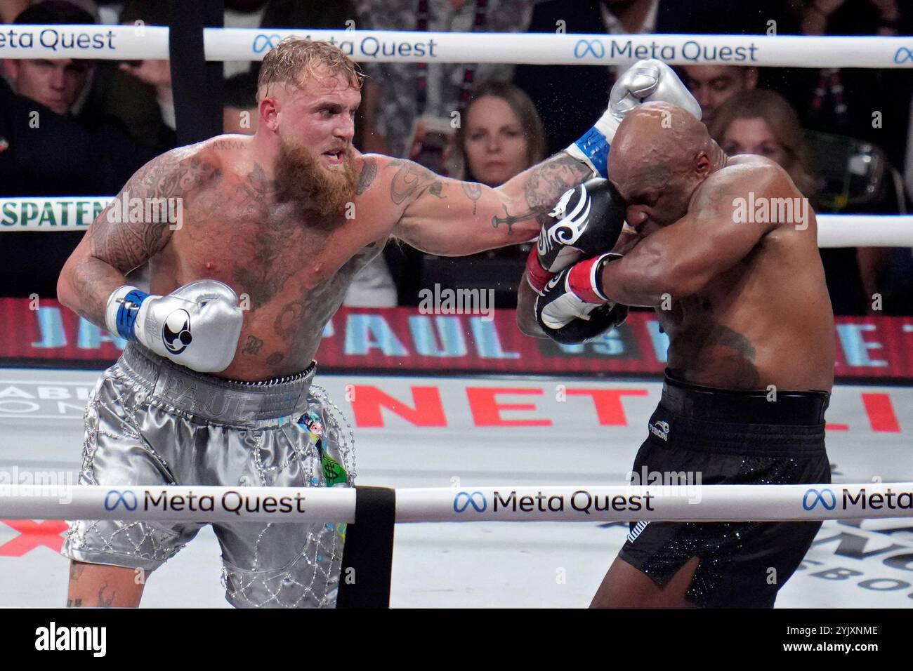 Jake Paul hits Mike Tyson during their heavyweight boxing match, Friday ...