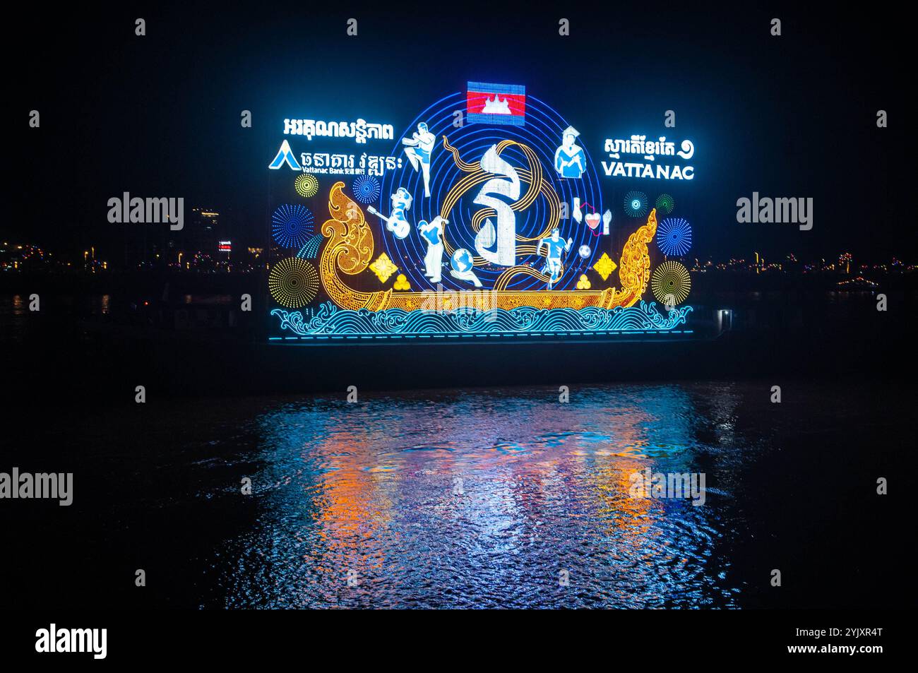 an Illuminated float / barge casts its reflection on the Tonle Sap ...
