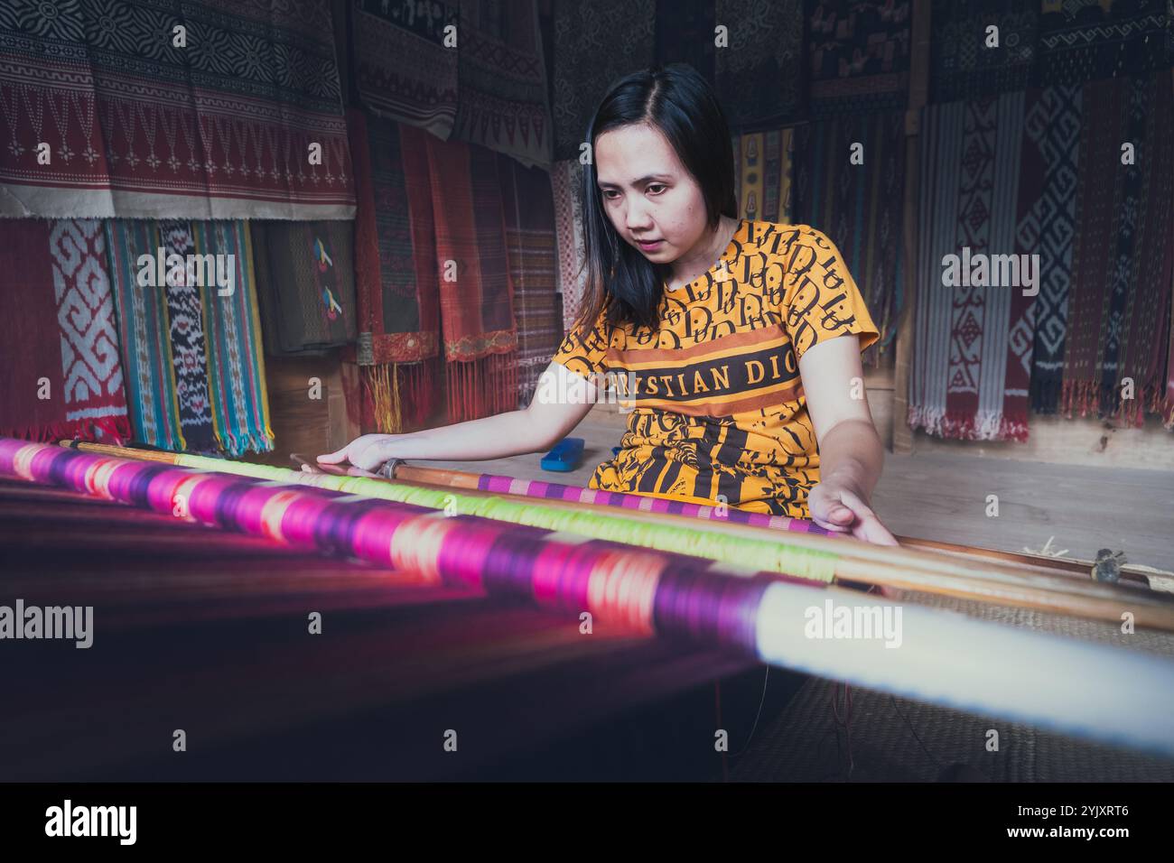 A Torajan Sa'dan weaver woman works on her weaving, October 2, 2024 ...