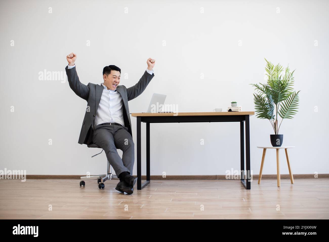 Asian businessman celebrating successful project completion at office ...