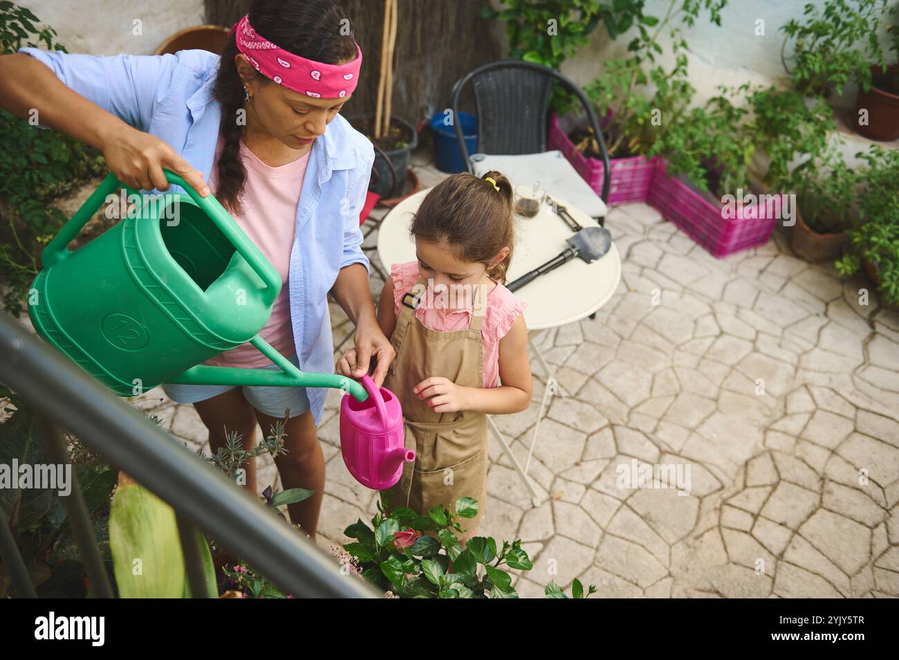 A mother and daughter spend quality time watering plants in their ...