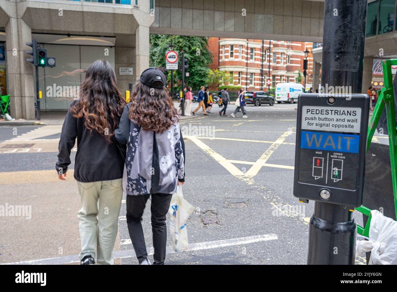 people crossing the road at the pedestrian crossing with traffic ...
