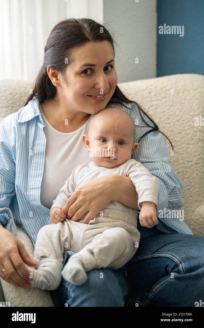 Cute little baby sitting on mums lap Stock Photo - Alamy