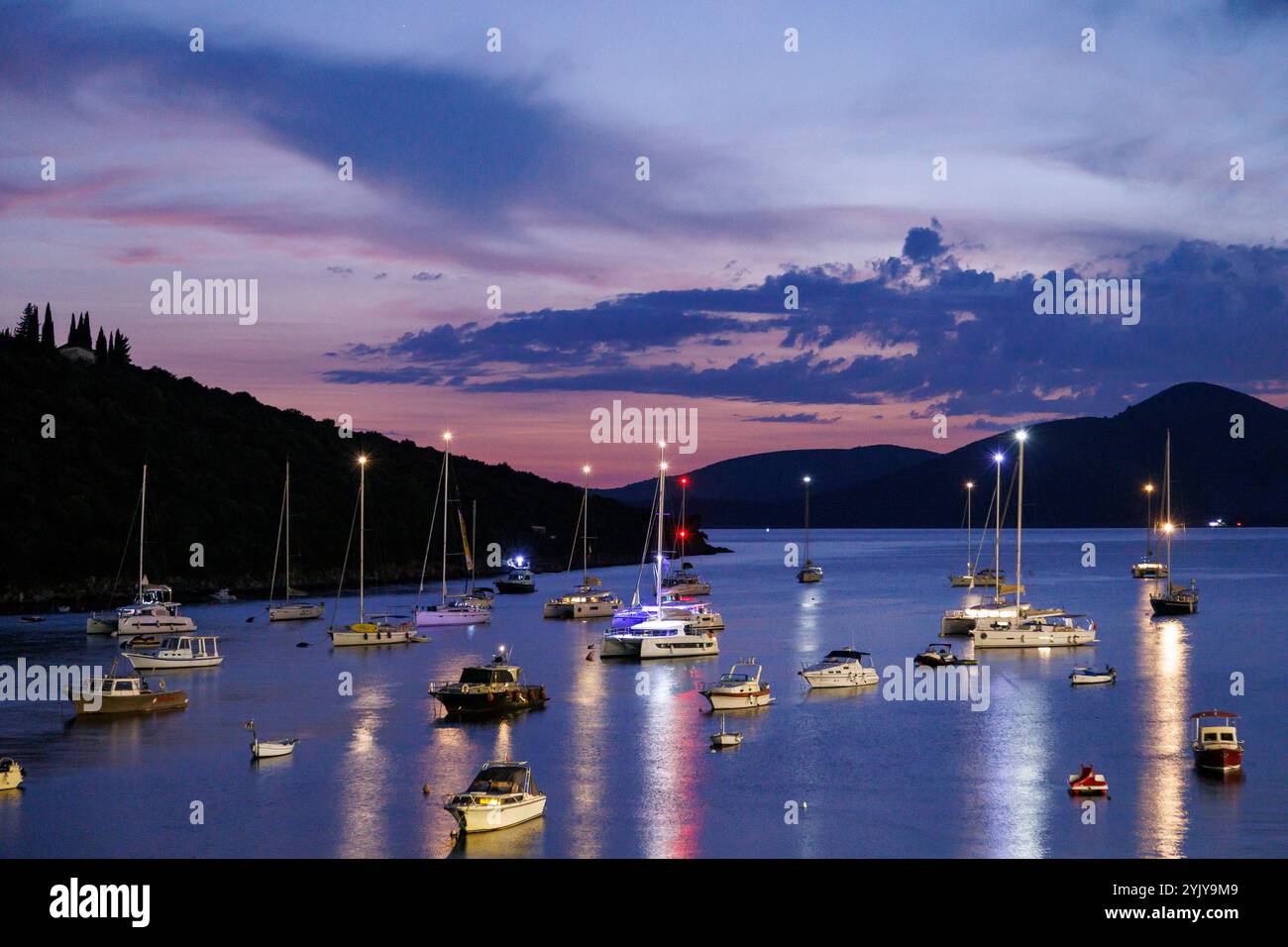 Aerial night view of little fisher village bay with yachts and ...