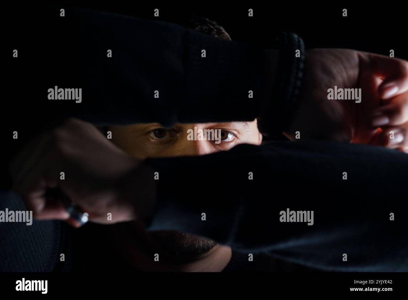 Introspective Gaze Amidst Shadows with Hands Framing the Face Stock ...