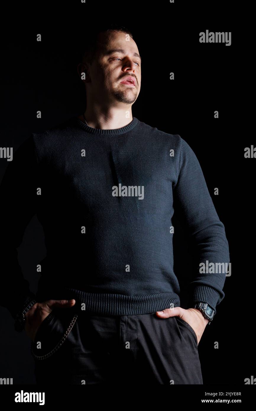 Introspective Male Figure in Dramatic Lighting Against a Black ...