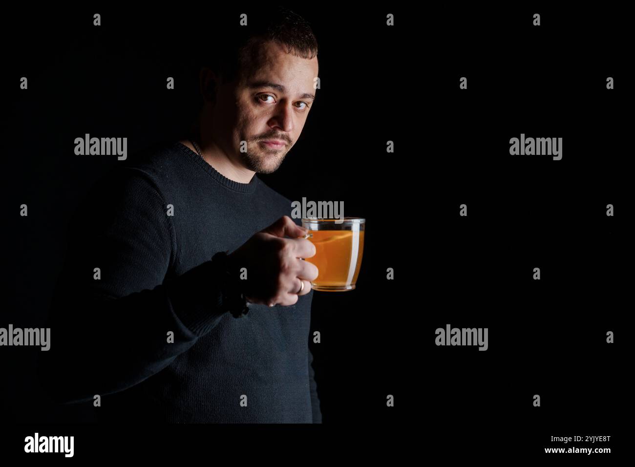 Introspective Man Posing with a Glass of Tea in Dim Lighting Stock ...