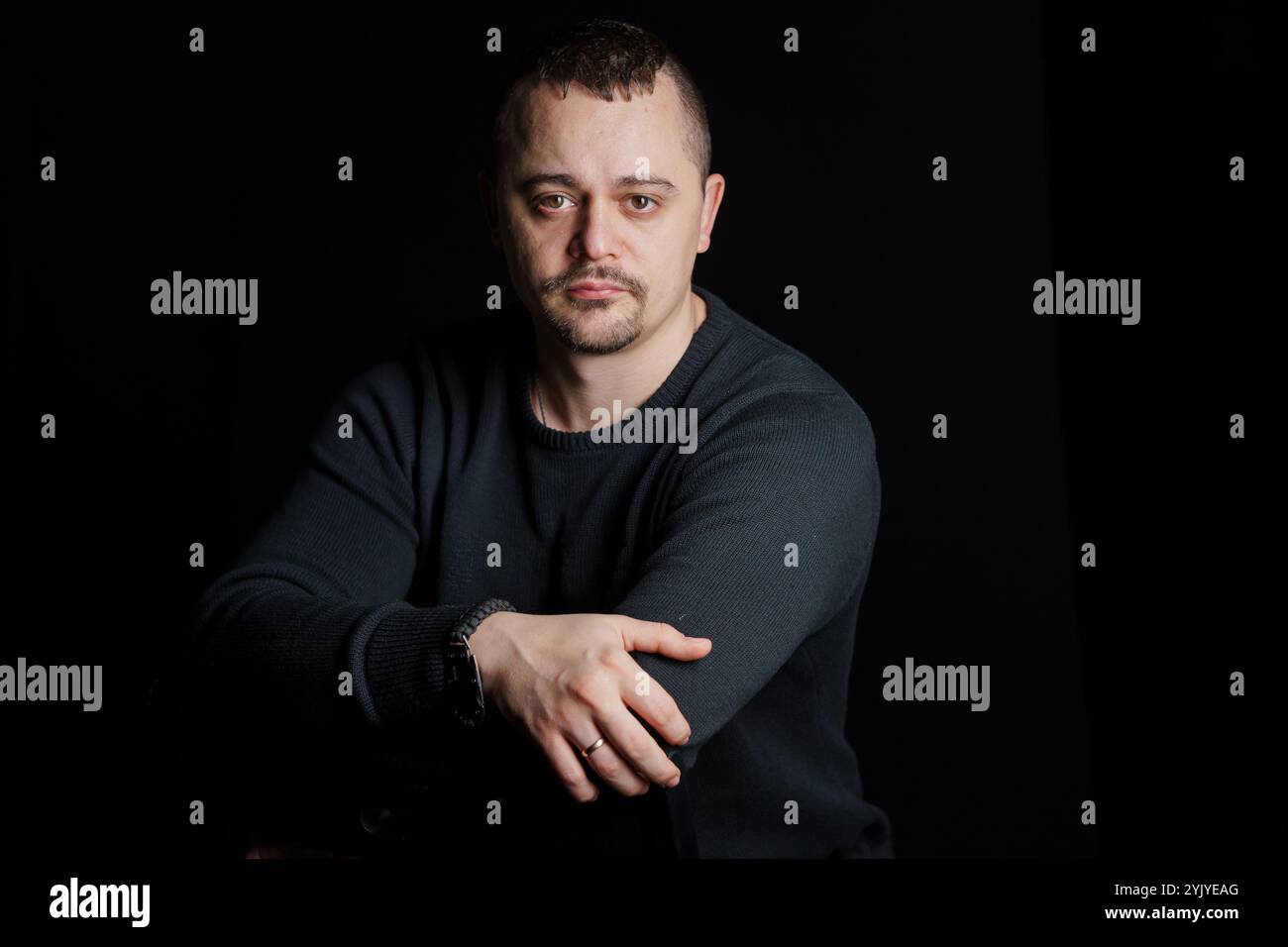 Introspective Man in Dark Studio Setting Stock Photo - Alamy