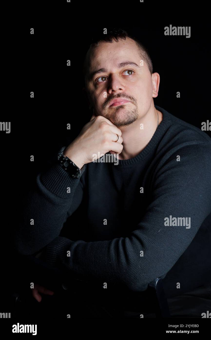 Contemplative Man in Dim Light Stock Photo - Alamy
