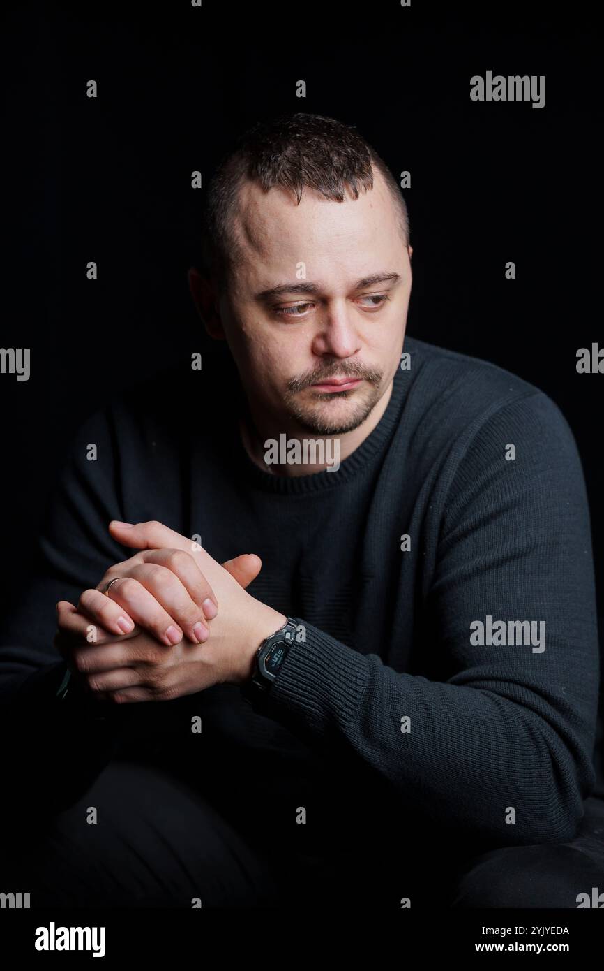 Contemplative Male in a Dark Setting Stock Photo - Alamy