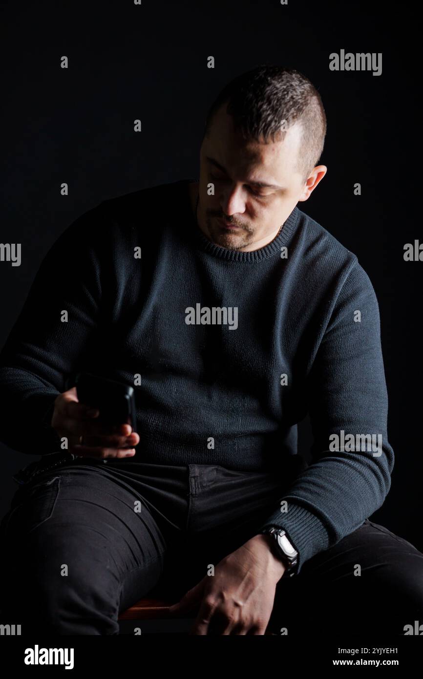 Introspective Man Engaged with His Smartphone in Low Light Stock Photo ...