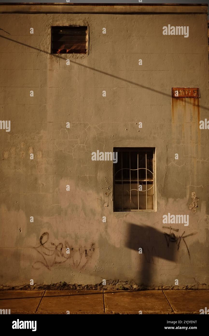 A flat rendered wall of a two story building, patches of painted over ...