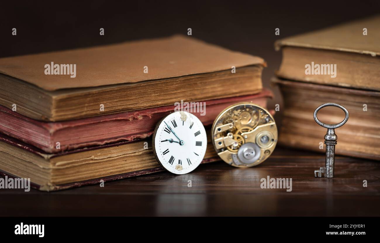 Antique old books with clock face, clockwork and key. Ancient mystery ...