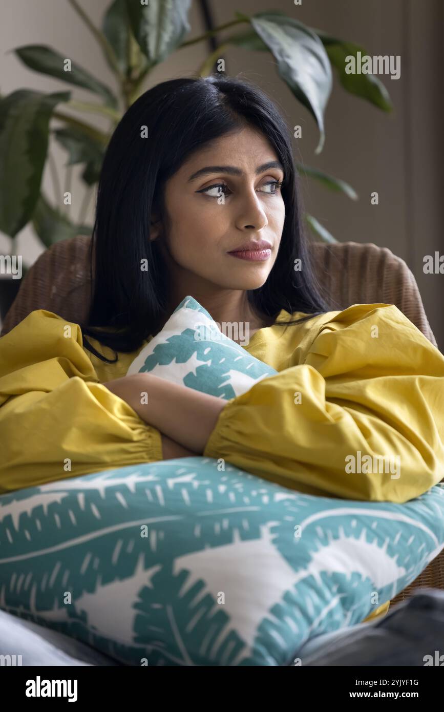 Concerned anxious young Indian woman sitting in home armchair Stock ...