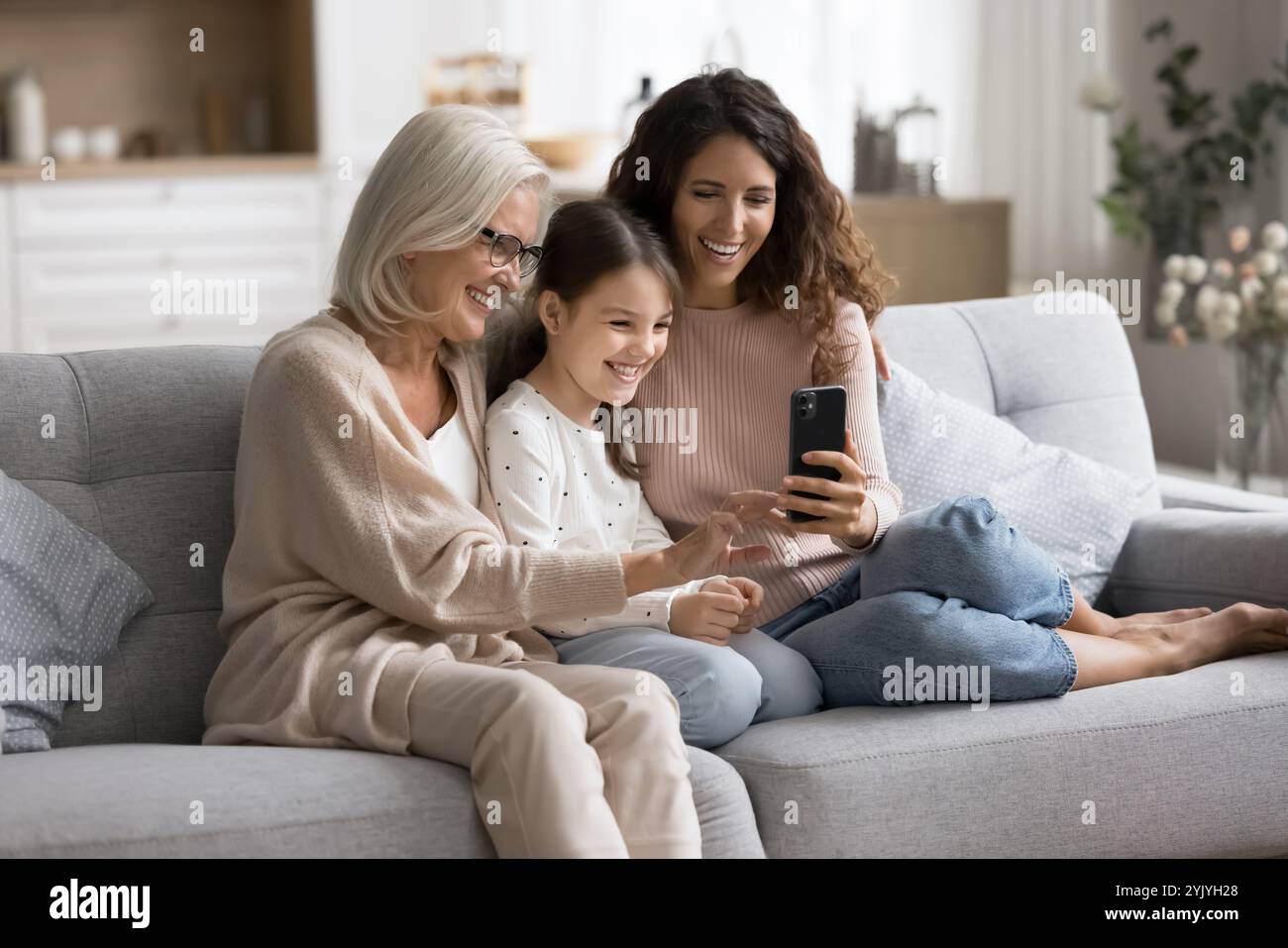Three women, kid, granny and adult female using smartphone together ...