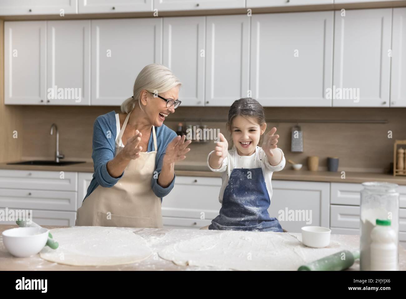 Family cooking, clapping hands smeared with white flour in kitchen ...