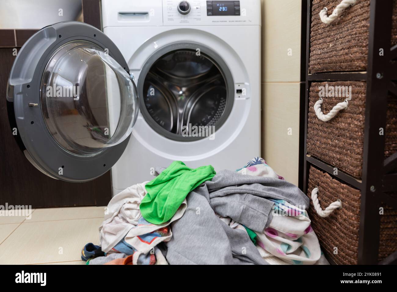 Setting Up for Laundry Day with a Washing Machine and a Heap of Clothes ...
