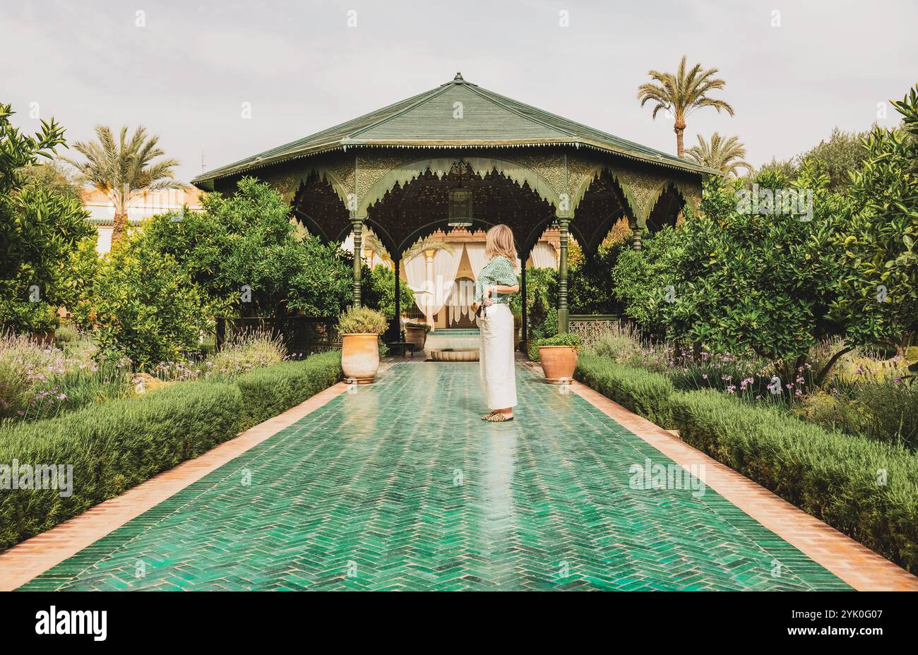 One young stylish woman sightseeing at Le Jardin Secret, lush green ...