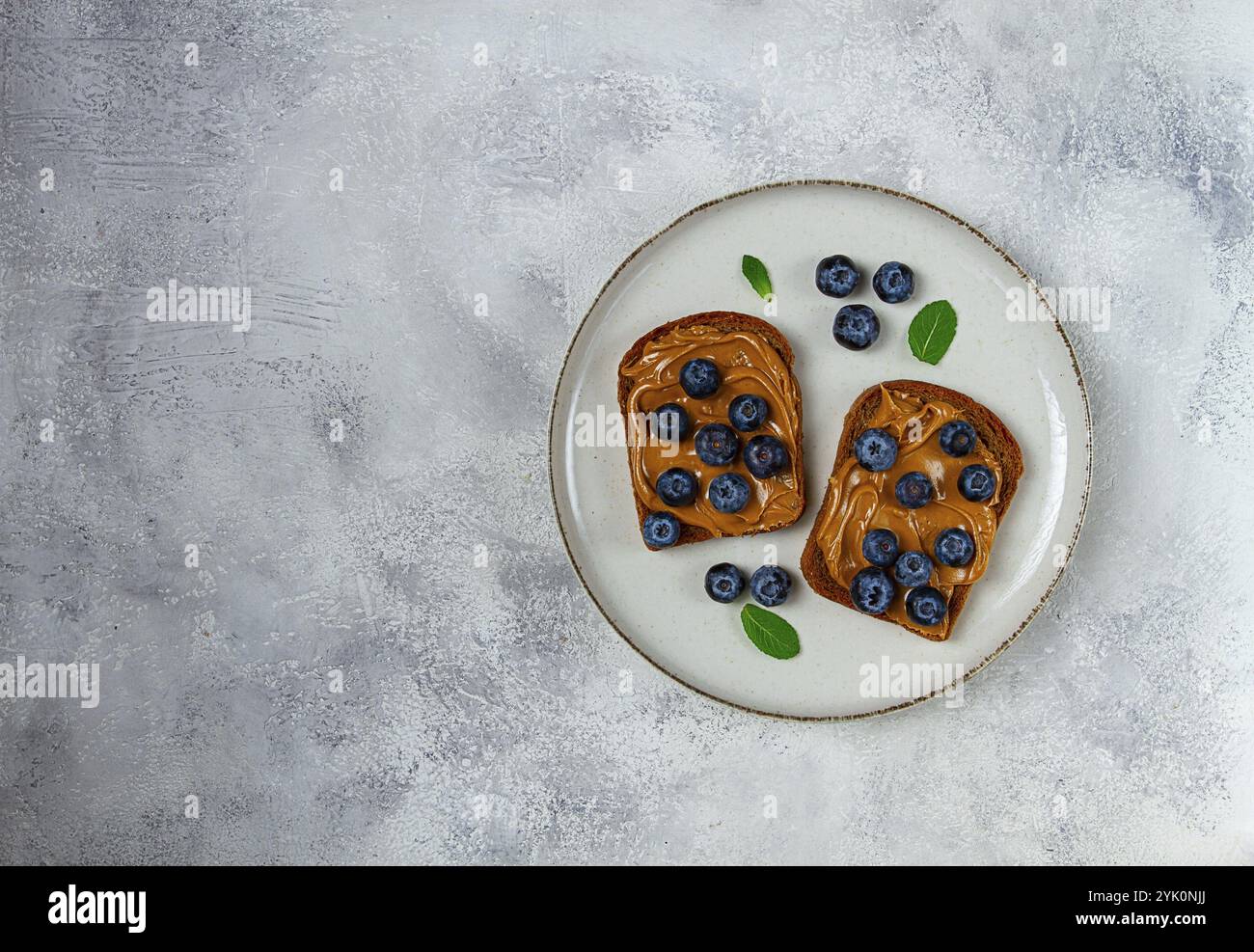 Rye bread with peanut paste and fresh blueberries, top view, no people ...