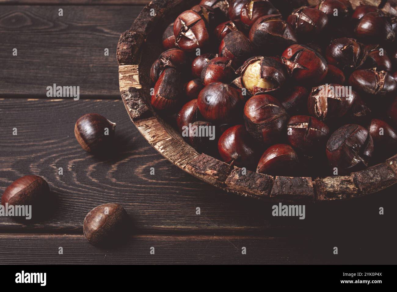 Roasted chestnuts, in a wooden plate, top view, homemade, no people ...