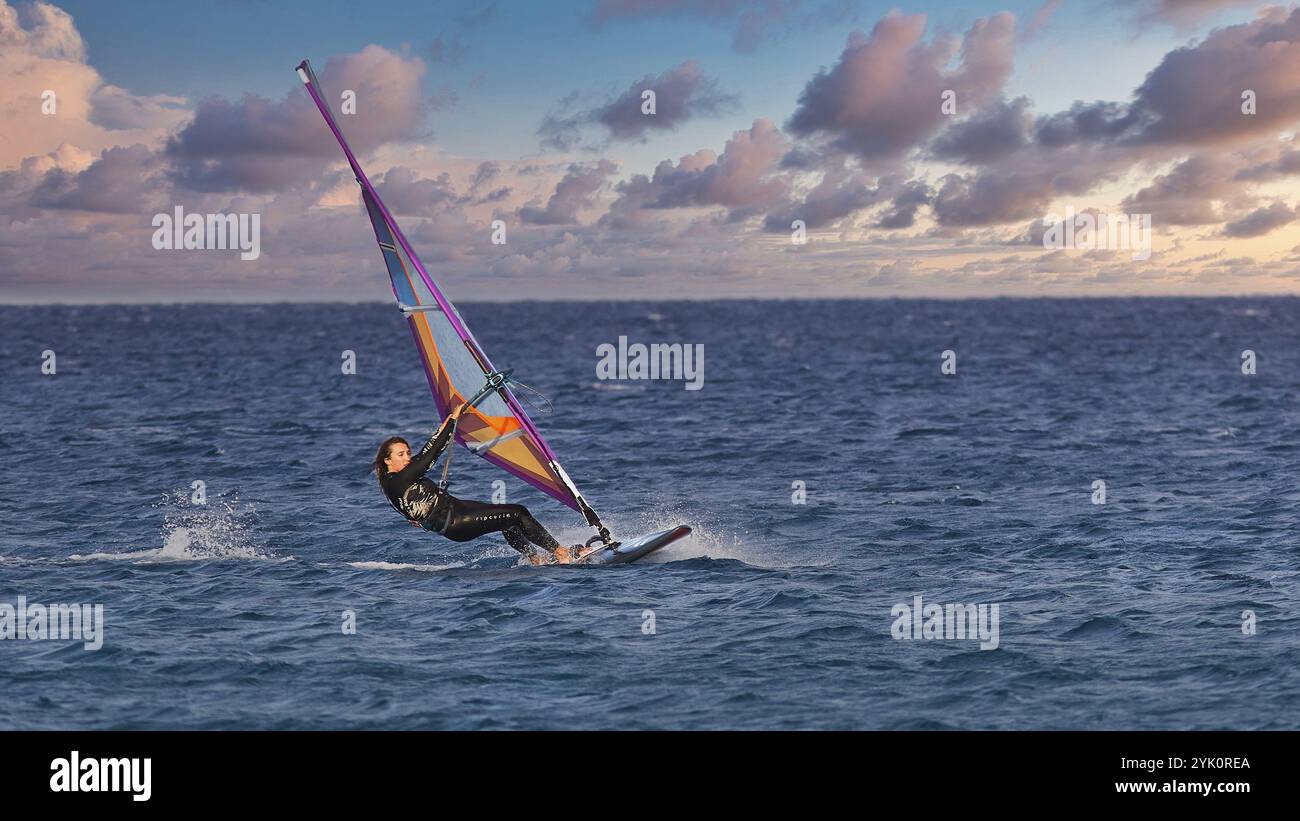 Sky exchanged, colourful windsurfer on the sea with vivid sky ...