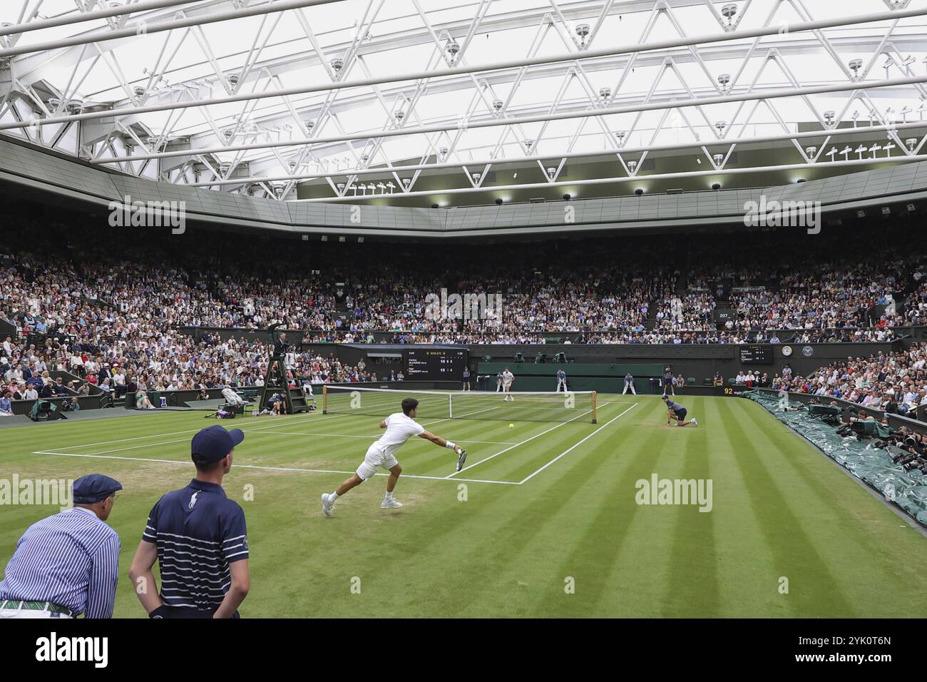 Spanish tennis player Carlos Alcaraz vs. Ugo Humbert (background) at the 2024 Wimbledon ...