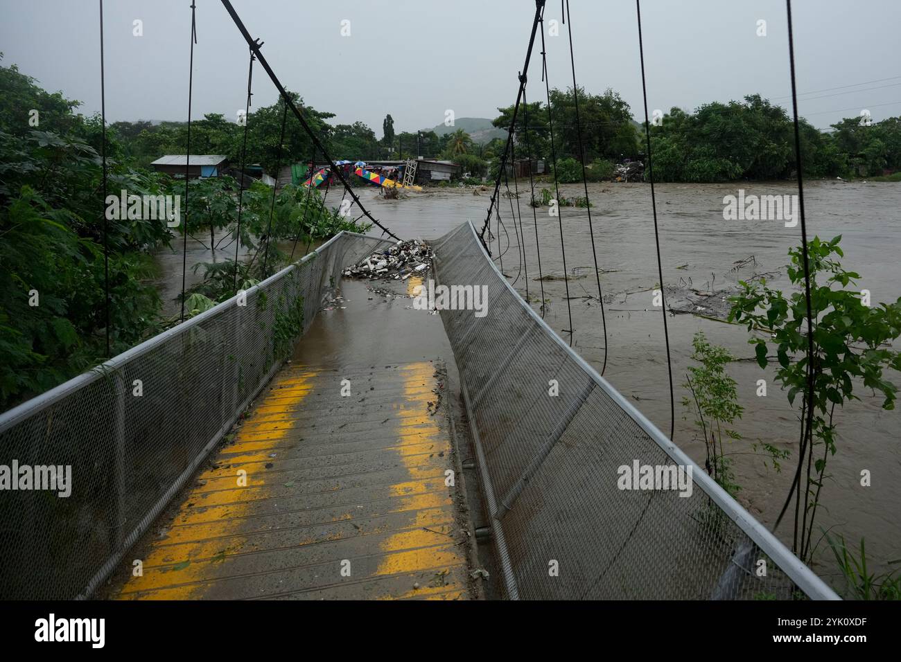 A pedestrian bridge collapsed due to flooding caused by rains brought ...
