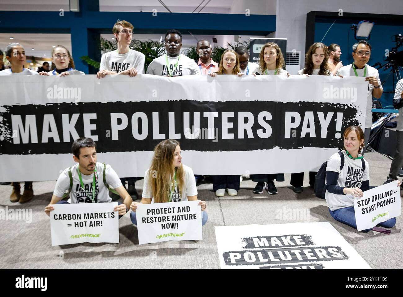 Climate activists hold a banner and placards during a protest to ...