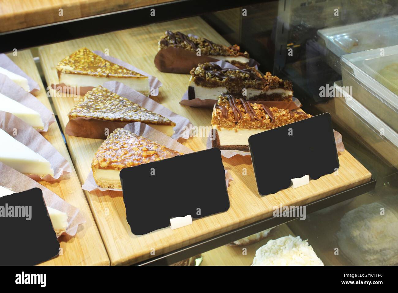 Pieces of cheesecake cakes in the window of a cafe store. Sale of ...