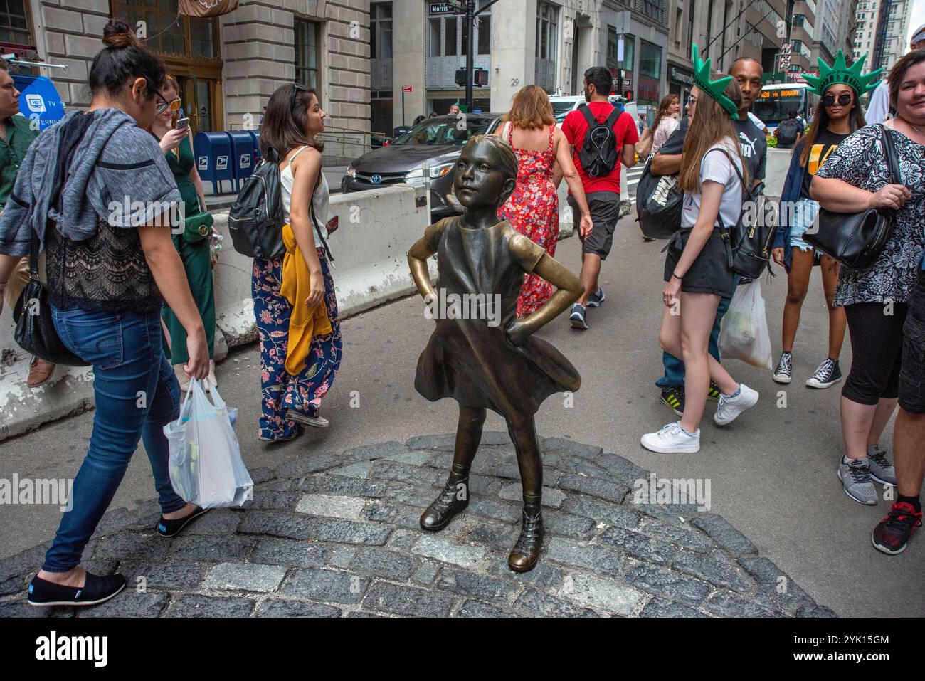 Tourists surrounding The Fearless Girl statue by Kristen Visbal ...