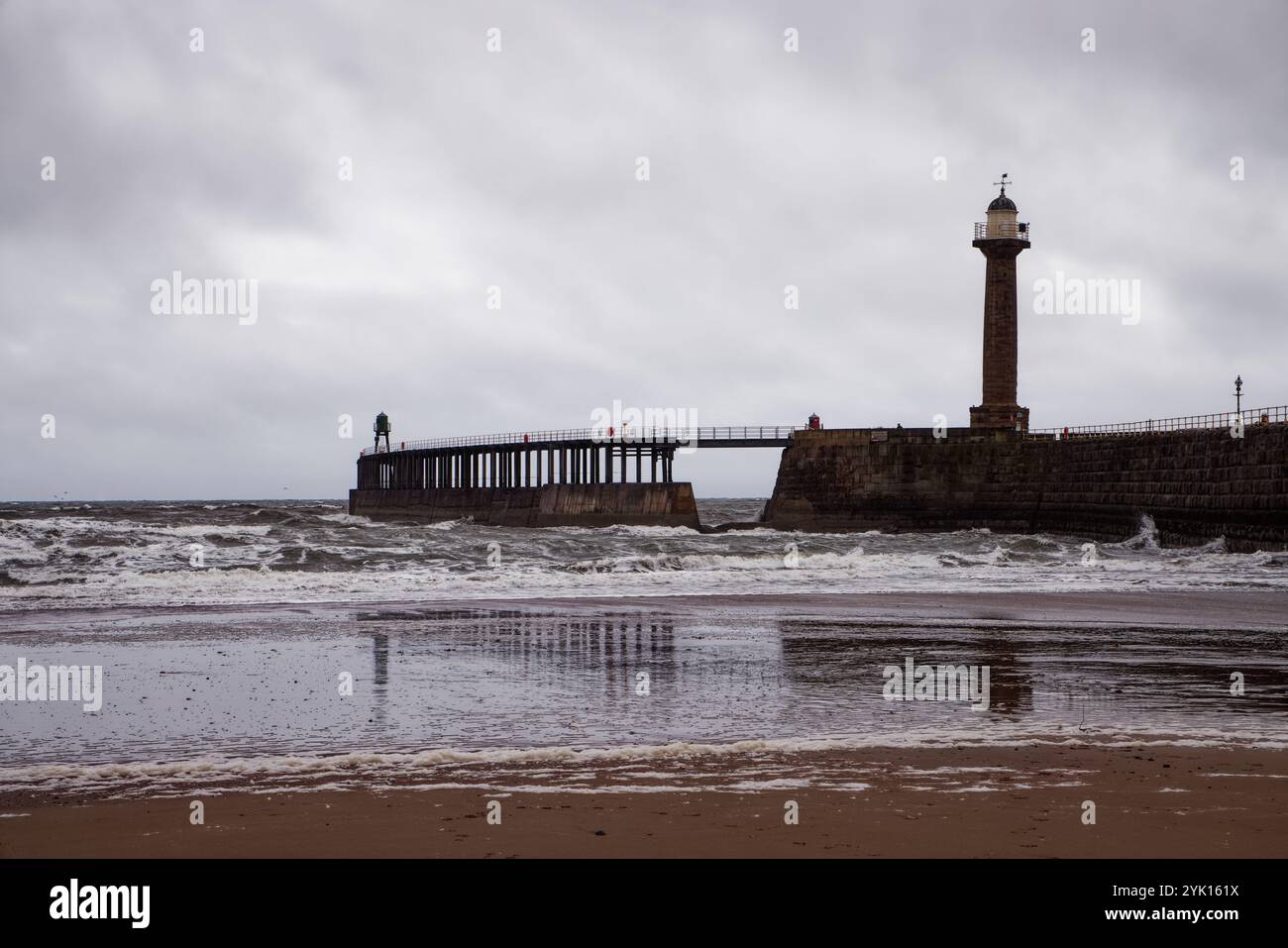 The lighthouse at Whitby Harbour stands tall on a stormy day at Whitby ...