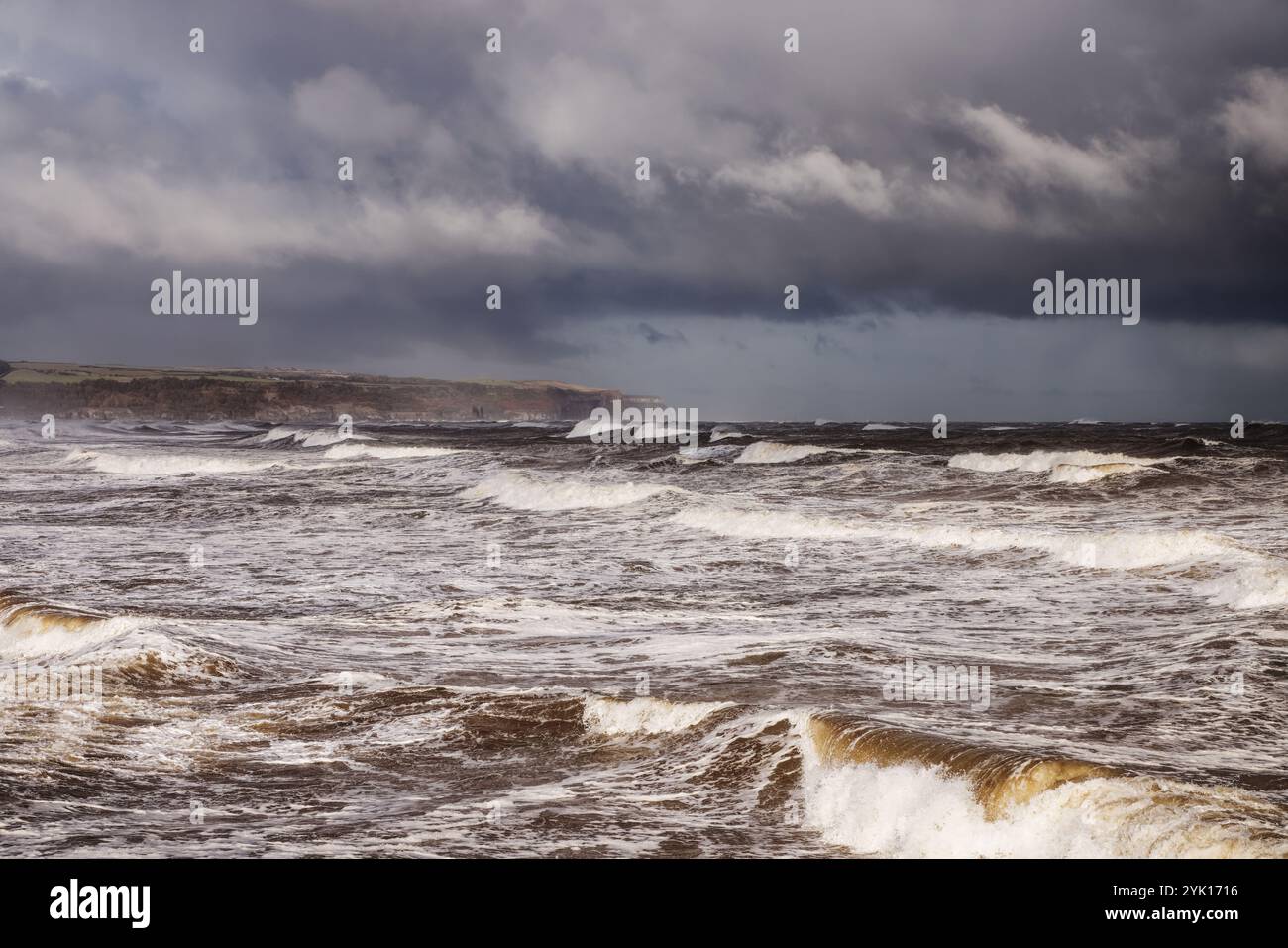 Rough seas at Whitby with misty cliffs in the background, North ...