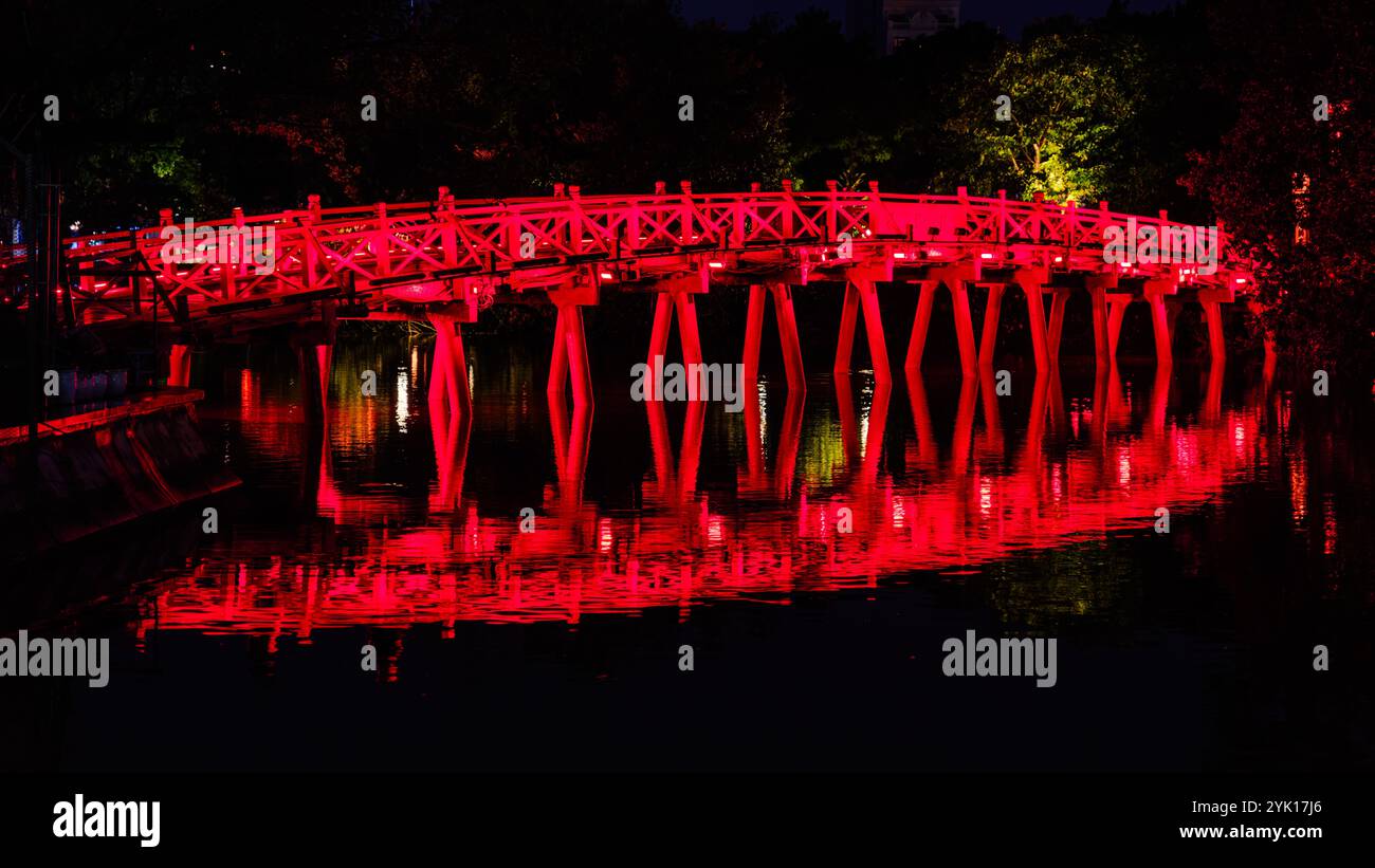 The illuminated red bridge at night over calm waters Stock Photo - Alamy