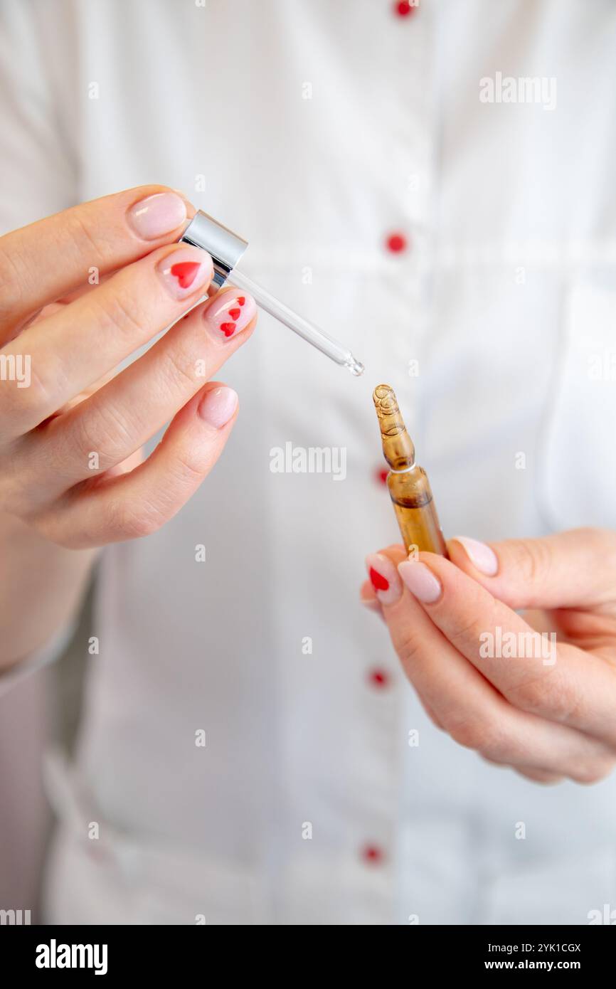 Vertical cropped female doctor pharmacist hands holding essential serum ...