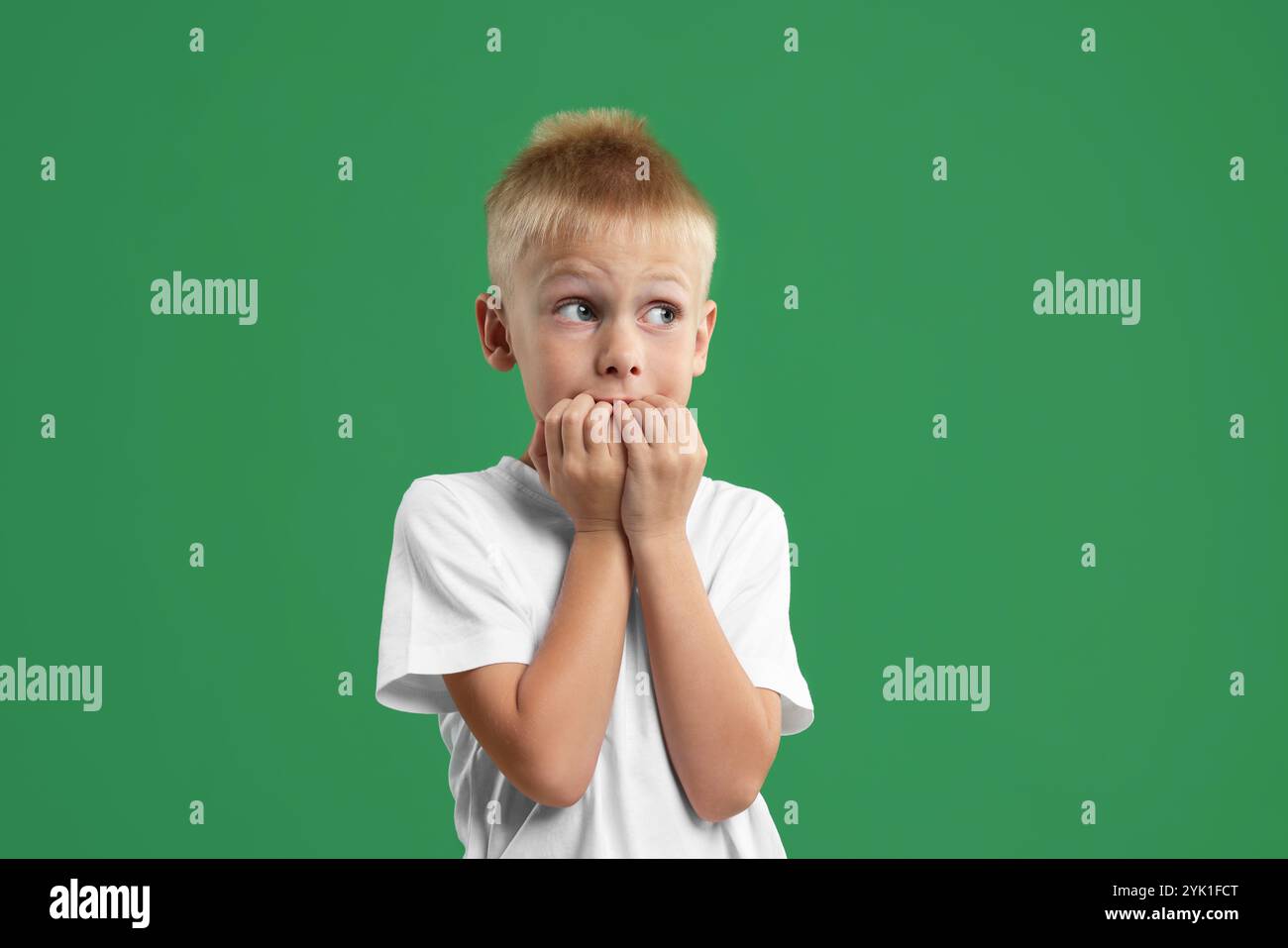 Portrait of scared little boy on green background Stock Photo - Alamy