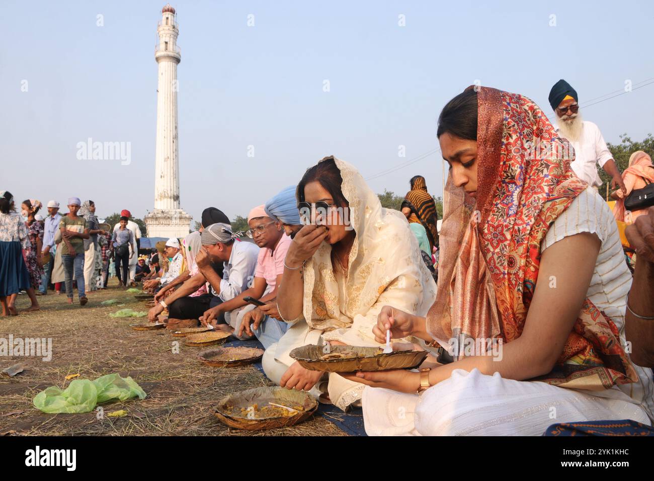 Non Exclusive: Devotees rest while eating on the occasion of the birth ...