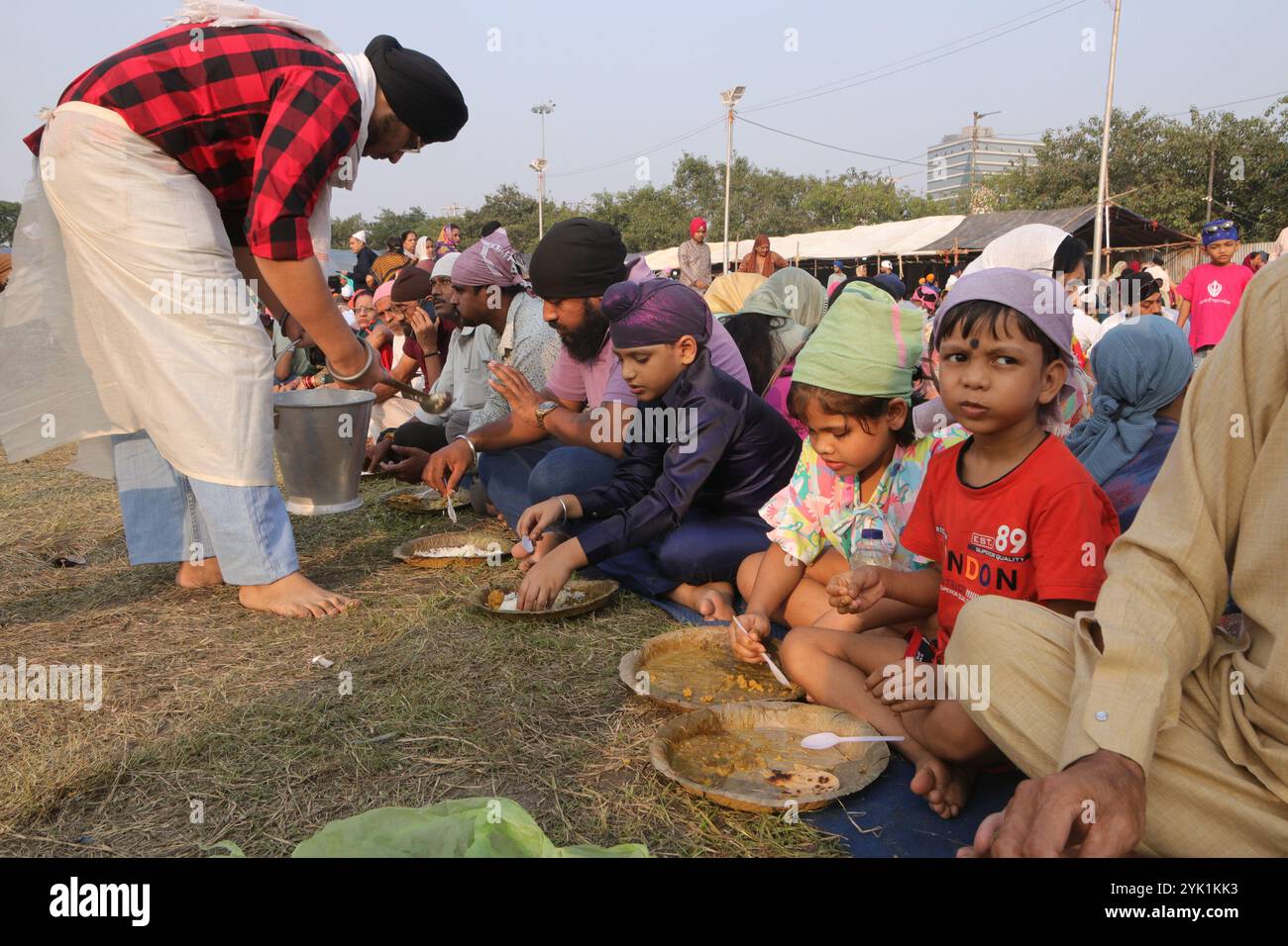 Non Exclusive: Devotees rest while eating on the occasion of the birth ...