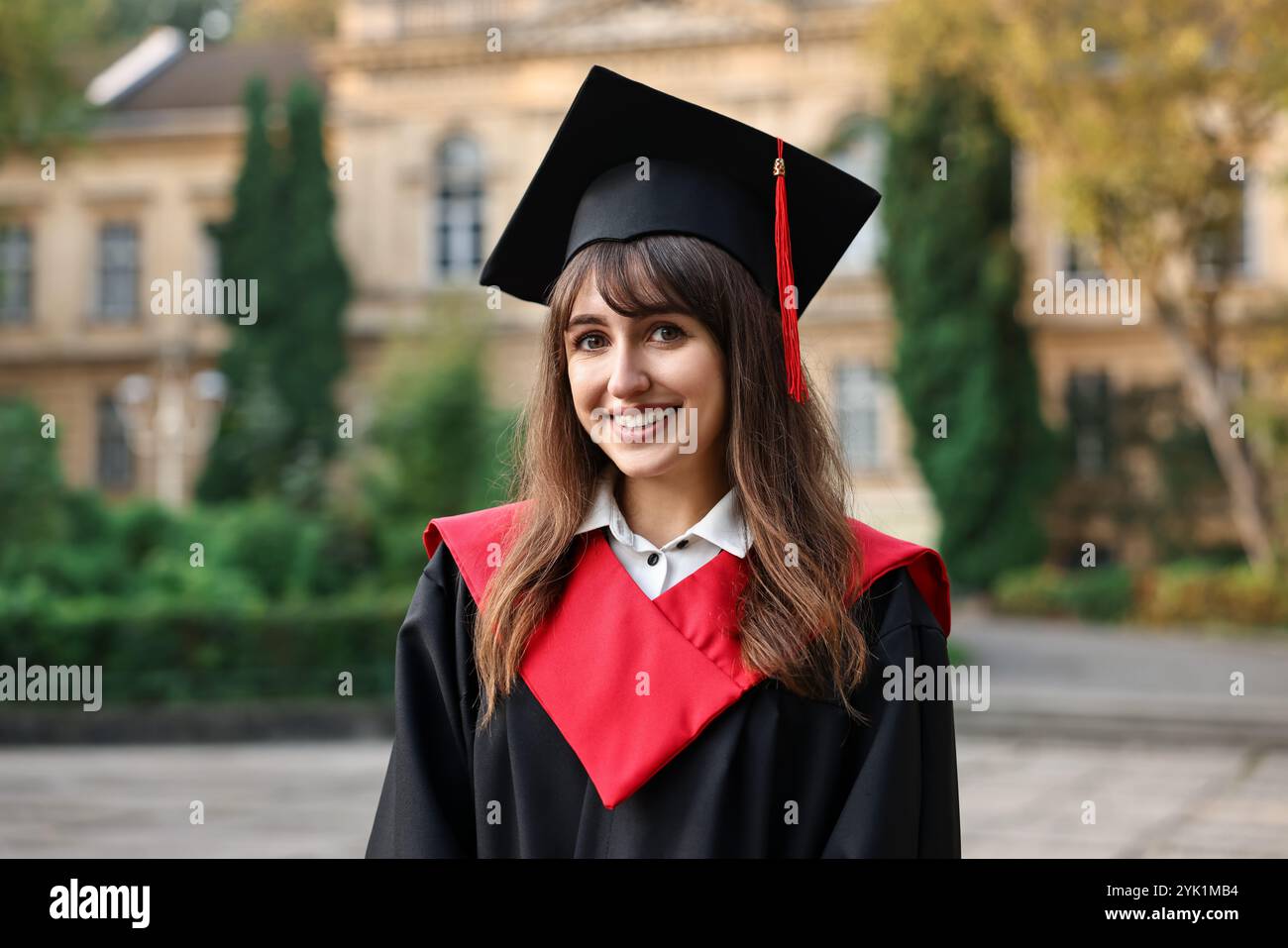Graduation ceremony. Happy student in academic dress outdoors Stock ...