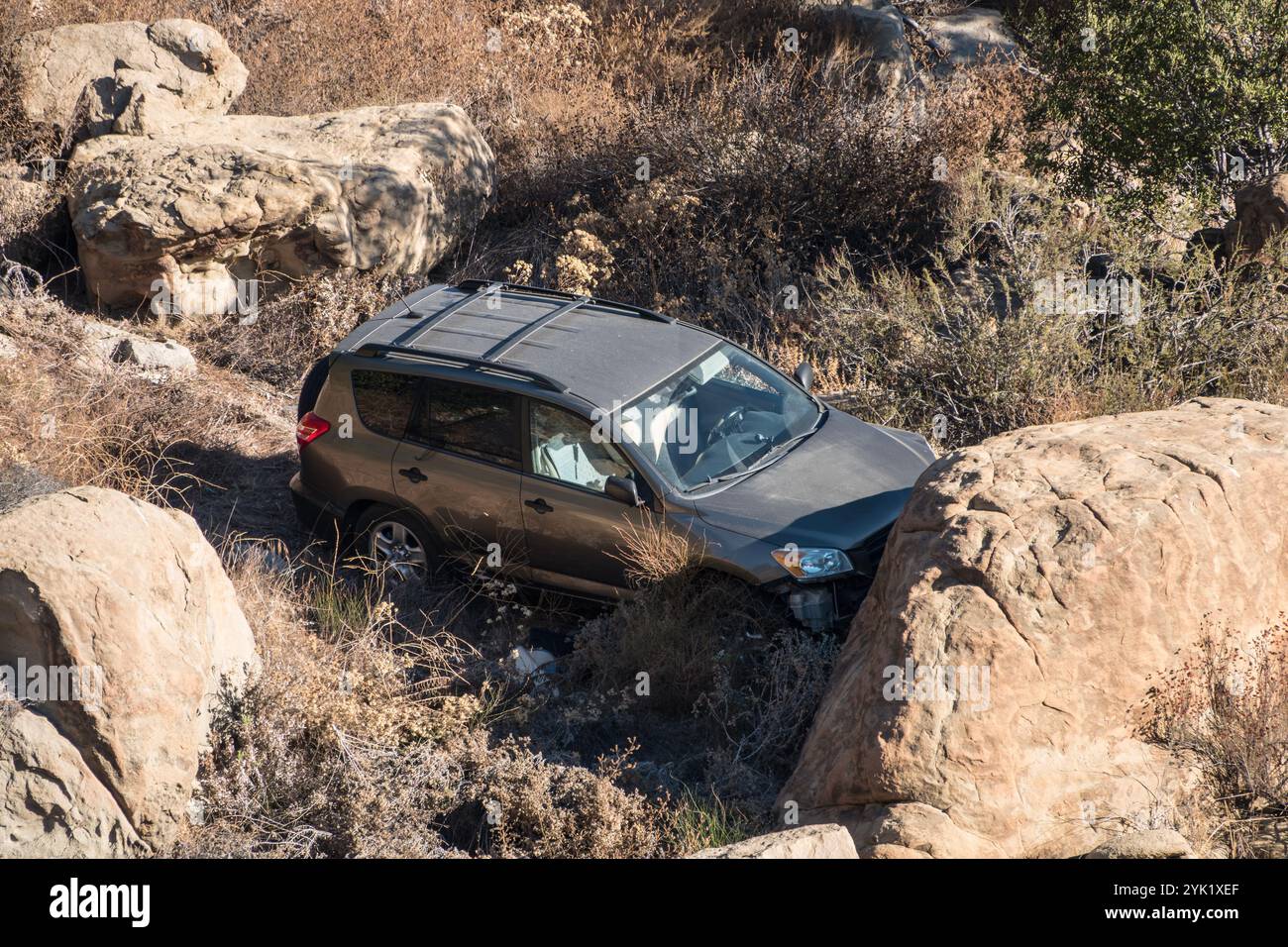 Wrecked car that drove off road into a rock and brush filled canyon in ...