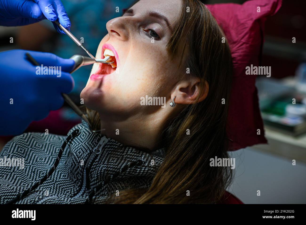 Dentist performing dental checkup on a patient's teeth using ...