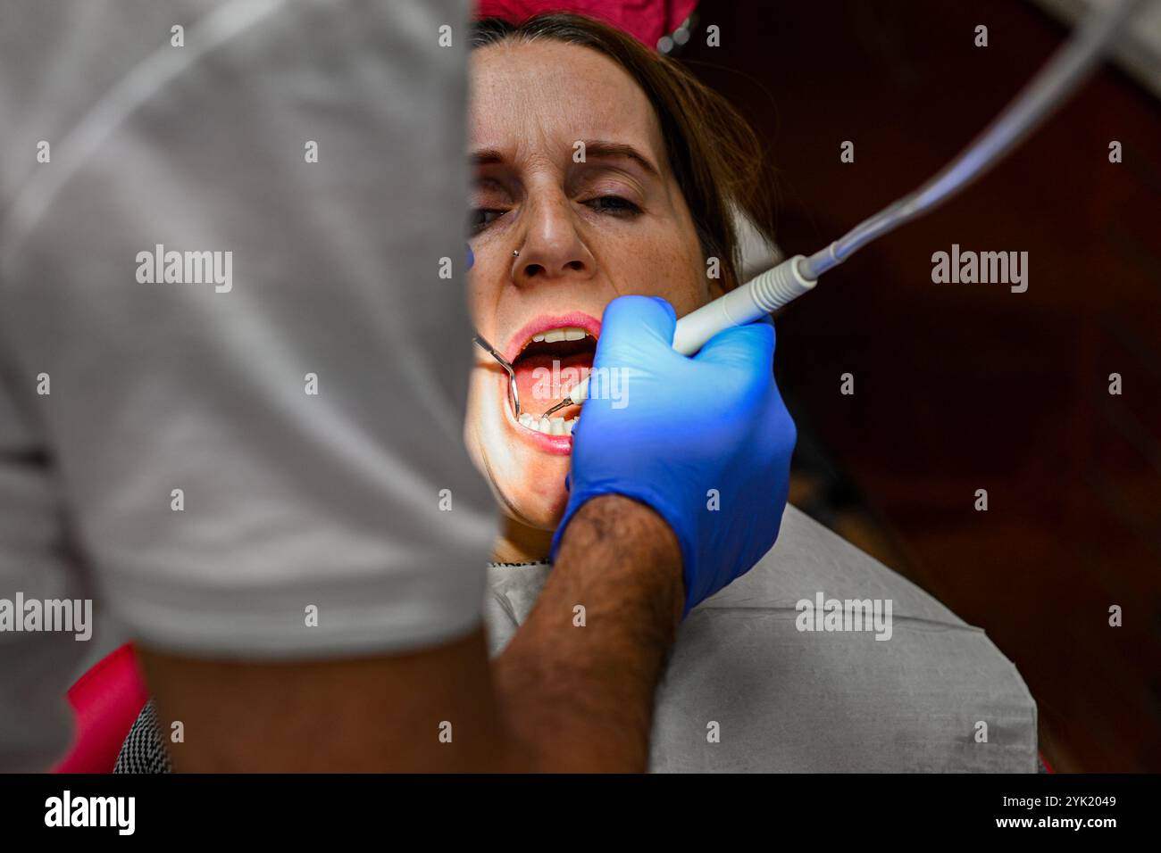 Dentist performing dental checkup on a patient's teeth using ...