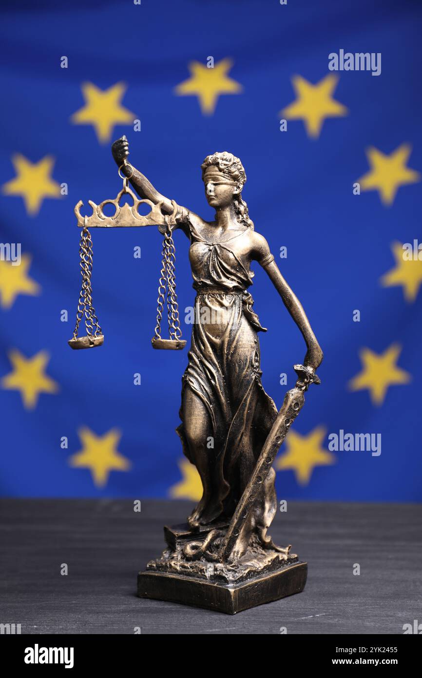 Figure of Lady Justice on grey table against European Union flag Stock ...