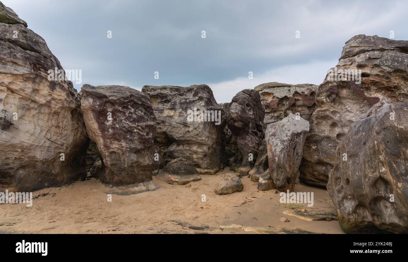 Massive rocks with weathered surfaces and unusual shapes under a gray ...