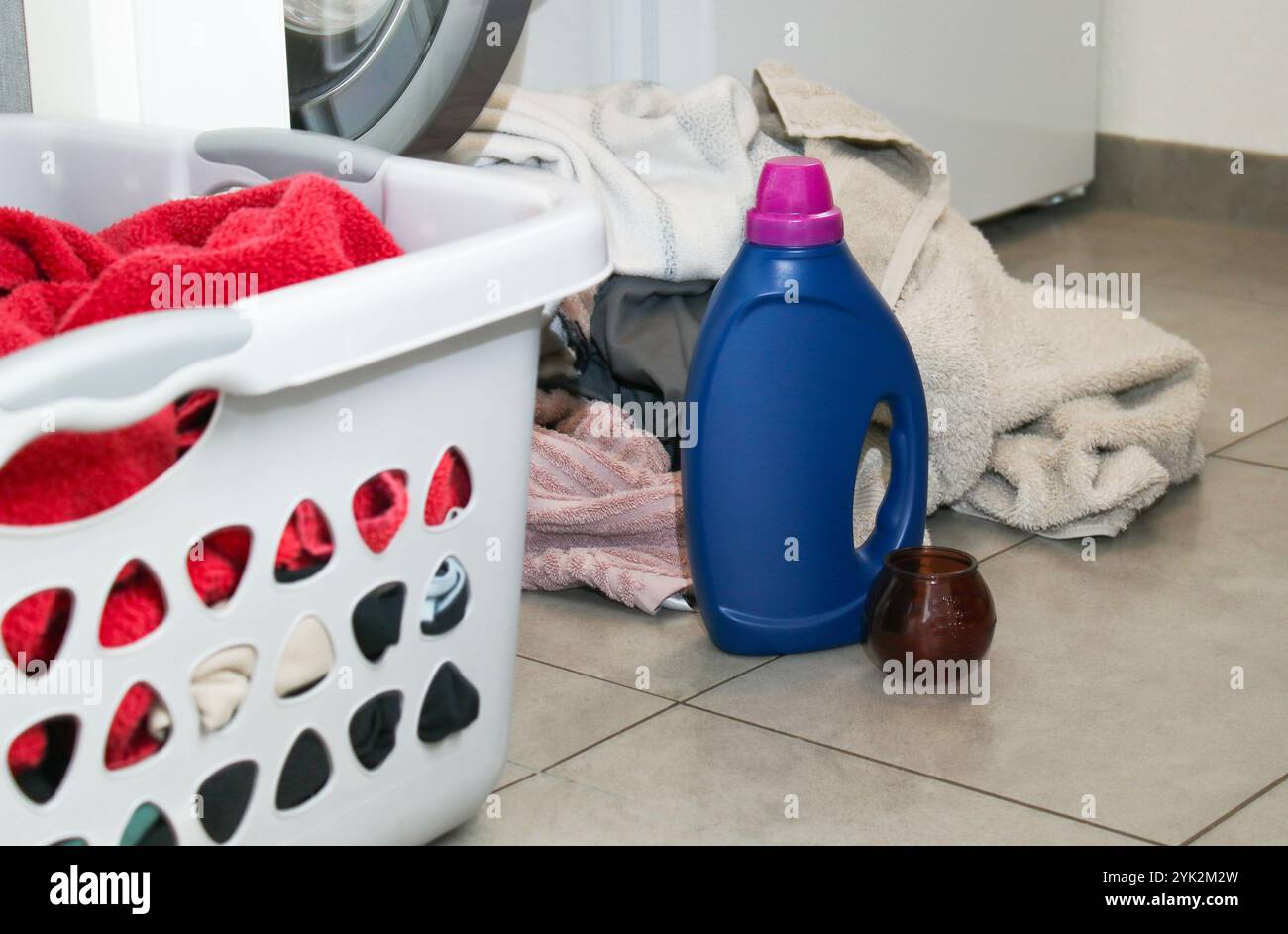 A blue bottle of liquid washing gel in a laundry basket near washing ...